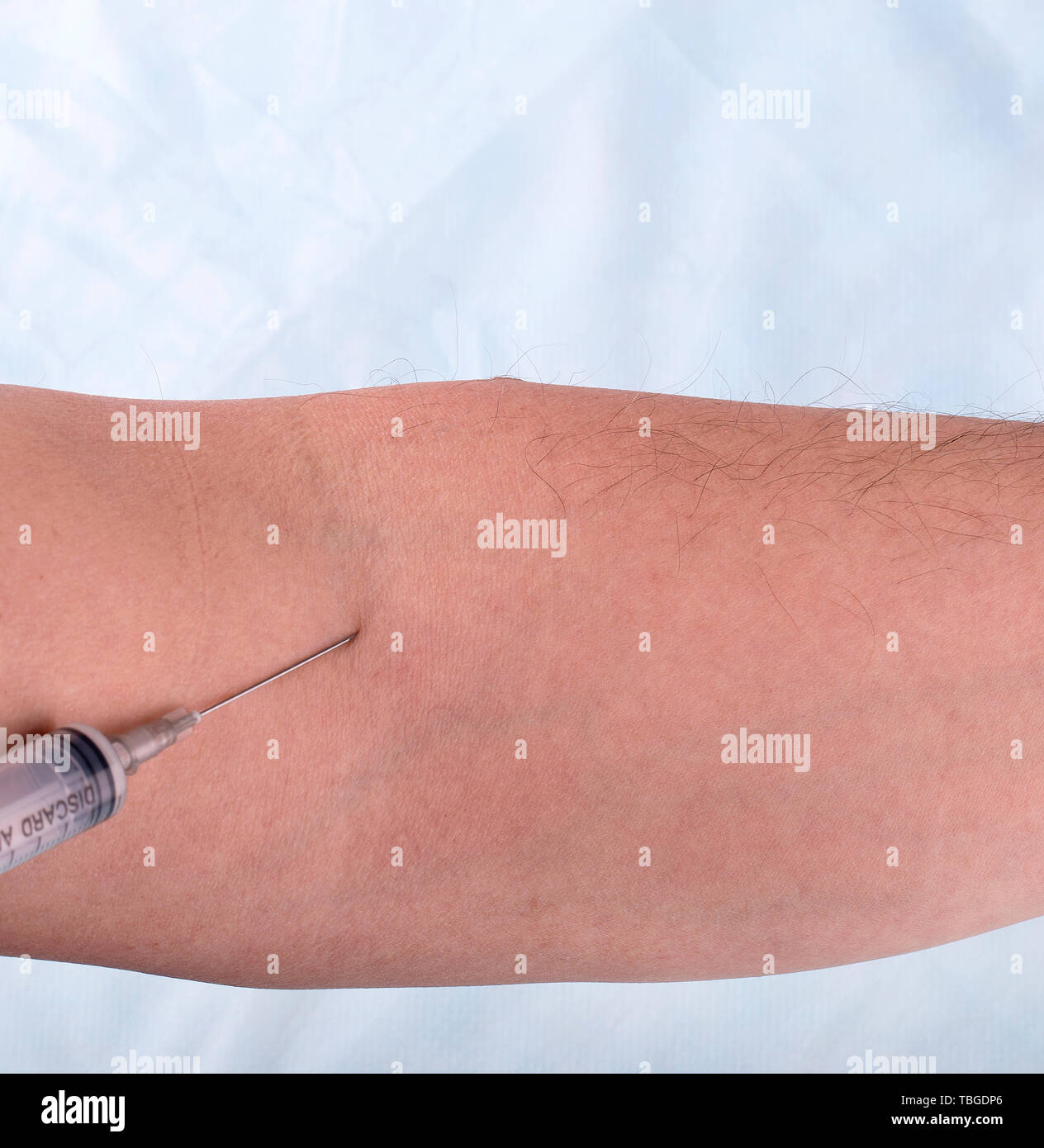 Close up nurse pricking needle syringe in the arm patient drawing blood ...