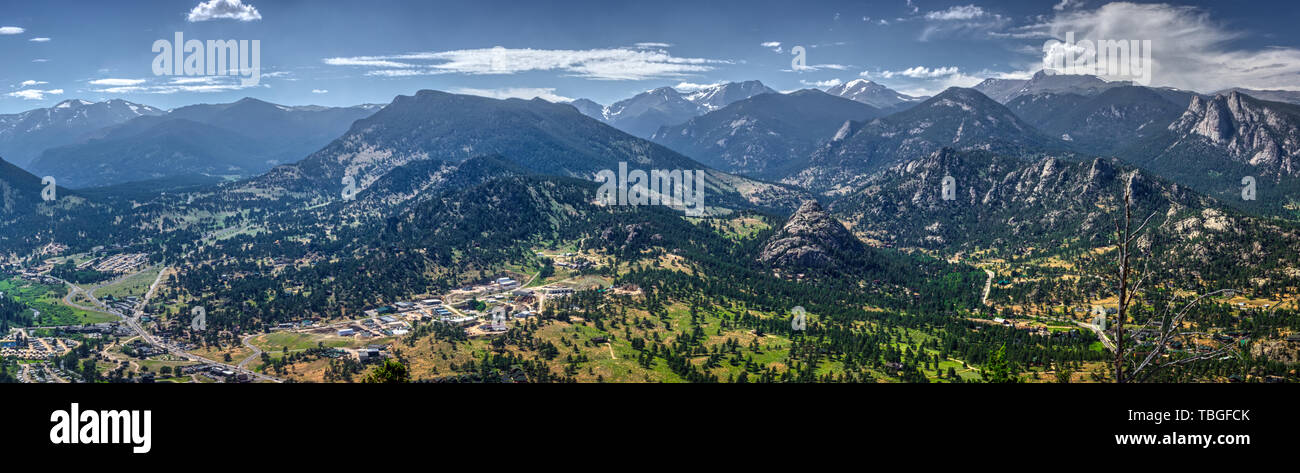 Scenic valley and snow-covered peaks under a blue sky with clouds in ...