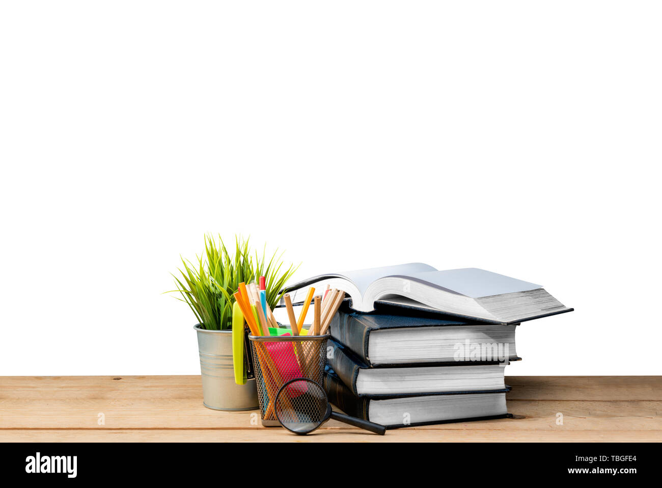 Pile of books with potted plant and pencils in basket container with ...