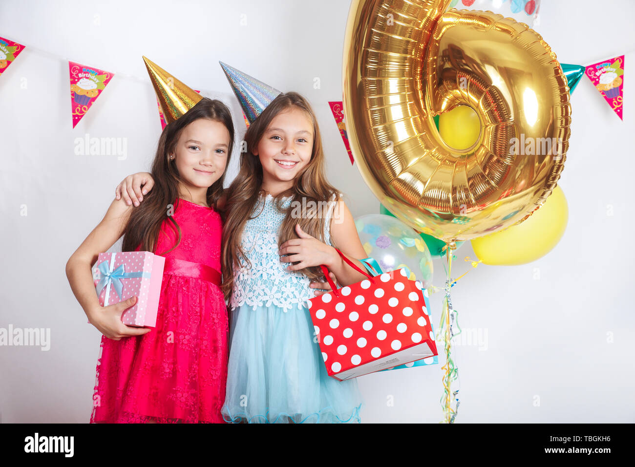 Two cute little girls with gifts on birthday party Stock Photo - Alamy