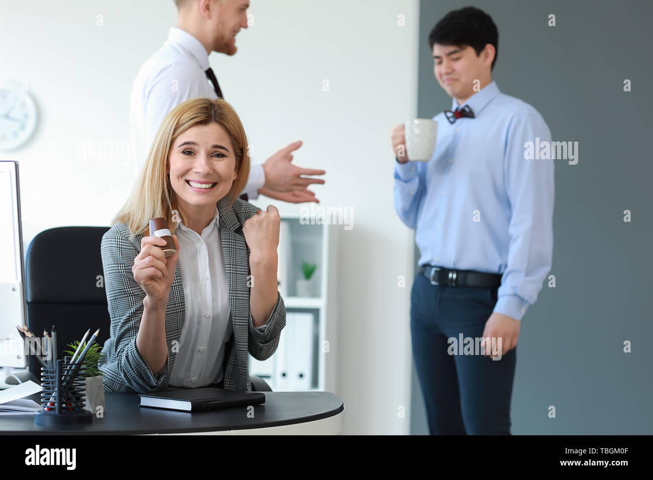 Woman playing a prank on her colleague in office. April Fools' Day ...