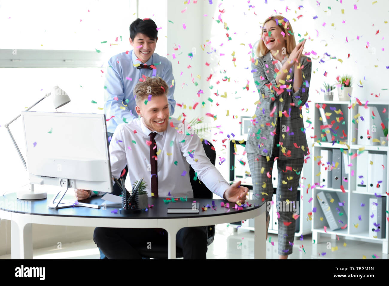 Friends playing a prank on their colleague in office. April Fools' Day ...