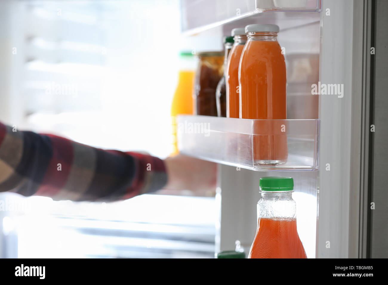 Man taking food out of fridge at home Stock Photo - Alamy