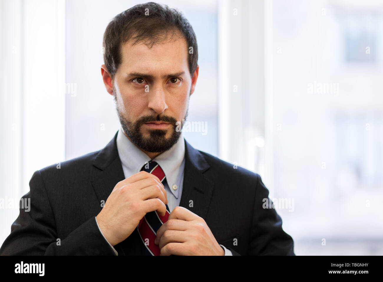 Young man adjusting tie and collar hi-res stock photography and images ...