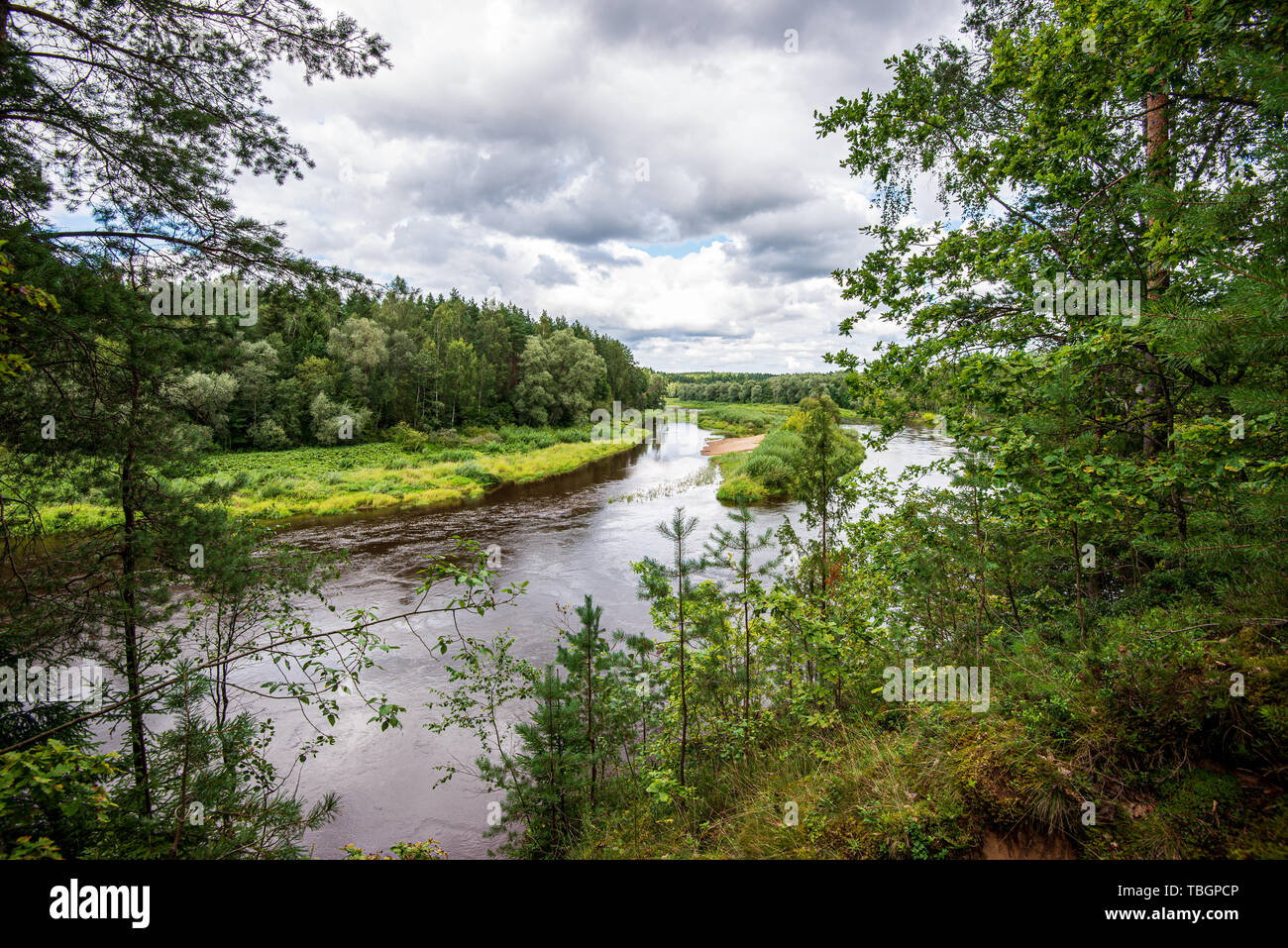 calm countryside lake river with cloud reflections in water and green ...