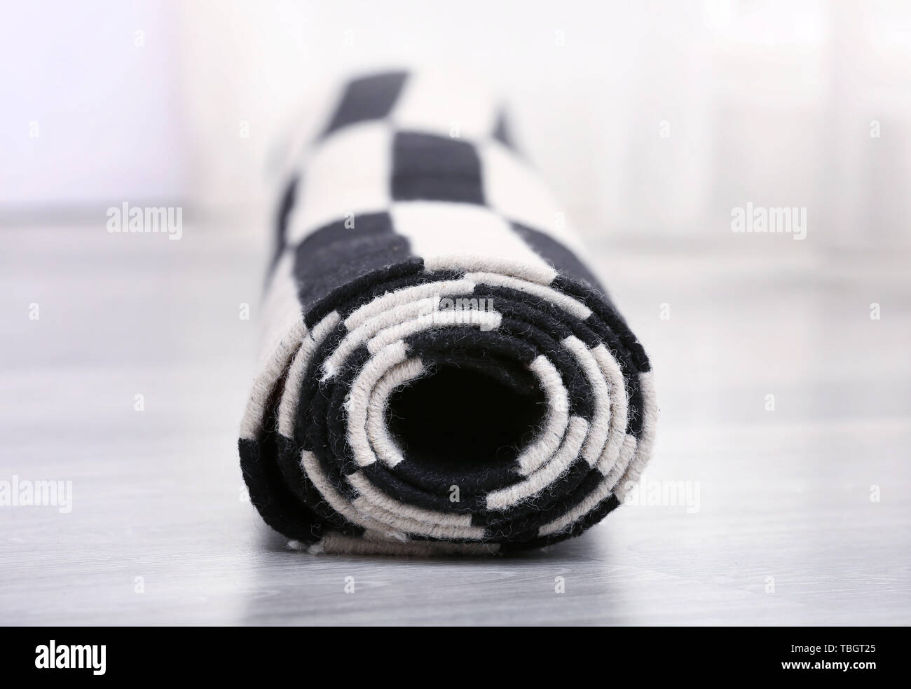 Rolled carpet on floor in room Stock Photo - Alamy