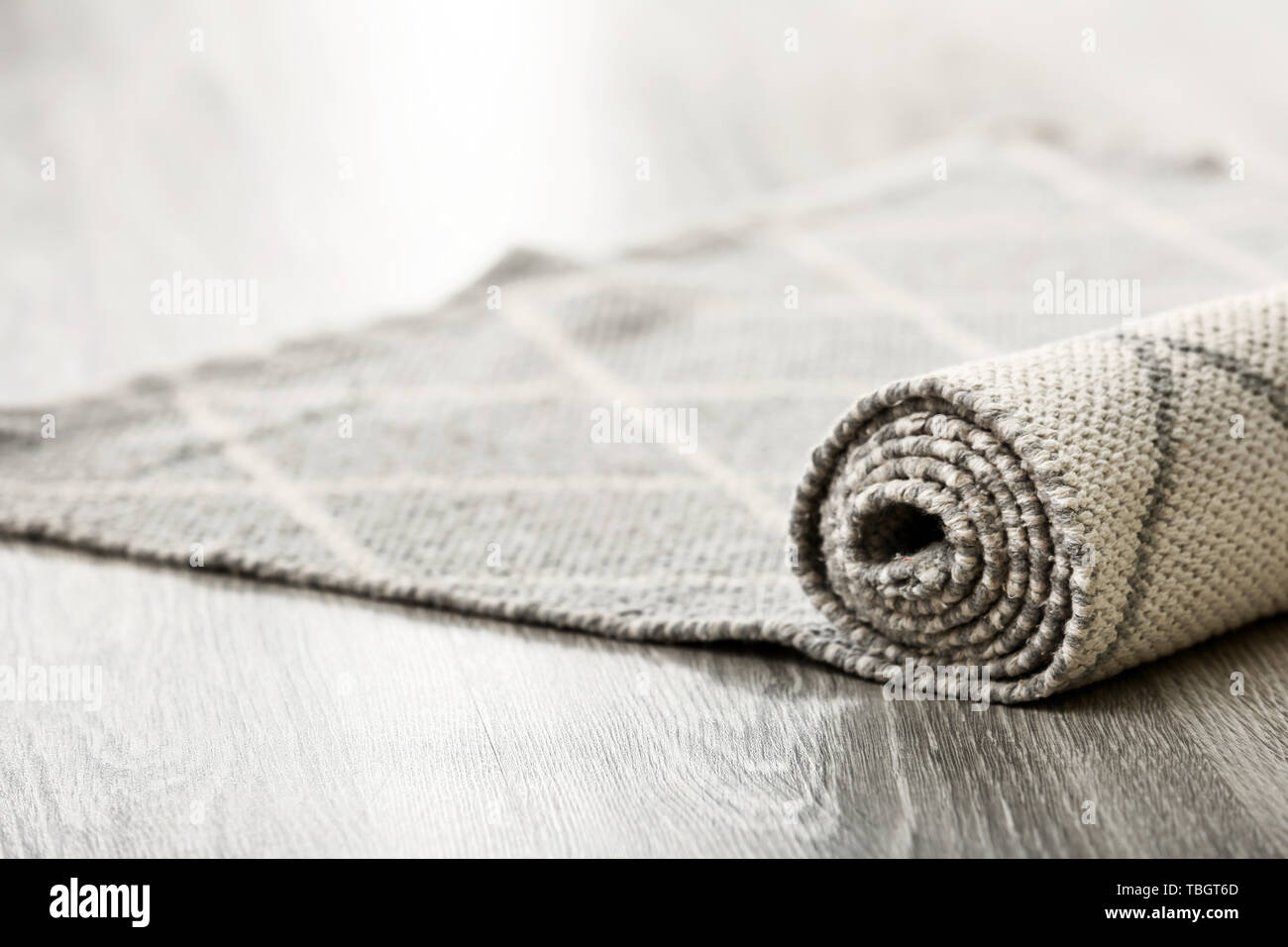 Rolled carpet on floor in room Stock Photo - Alamy