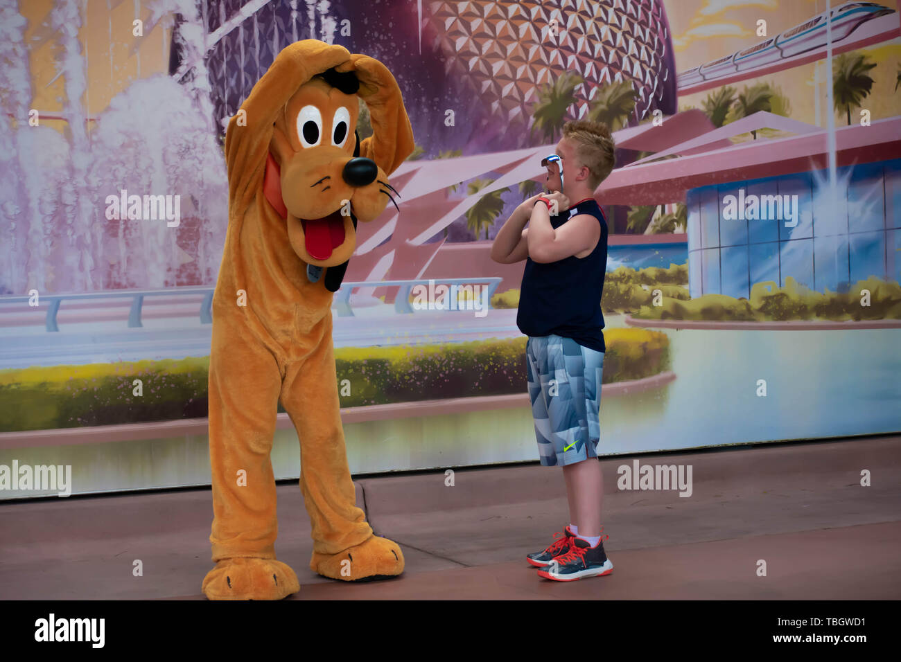 Orlando, Florida . March 27, 2019. Pluto playing with little boy at ...