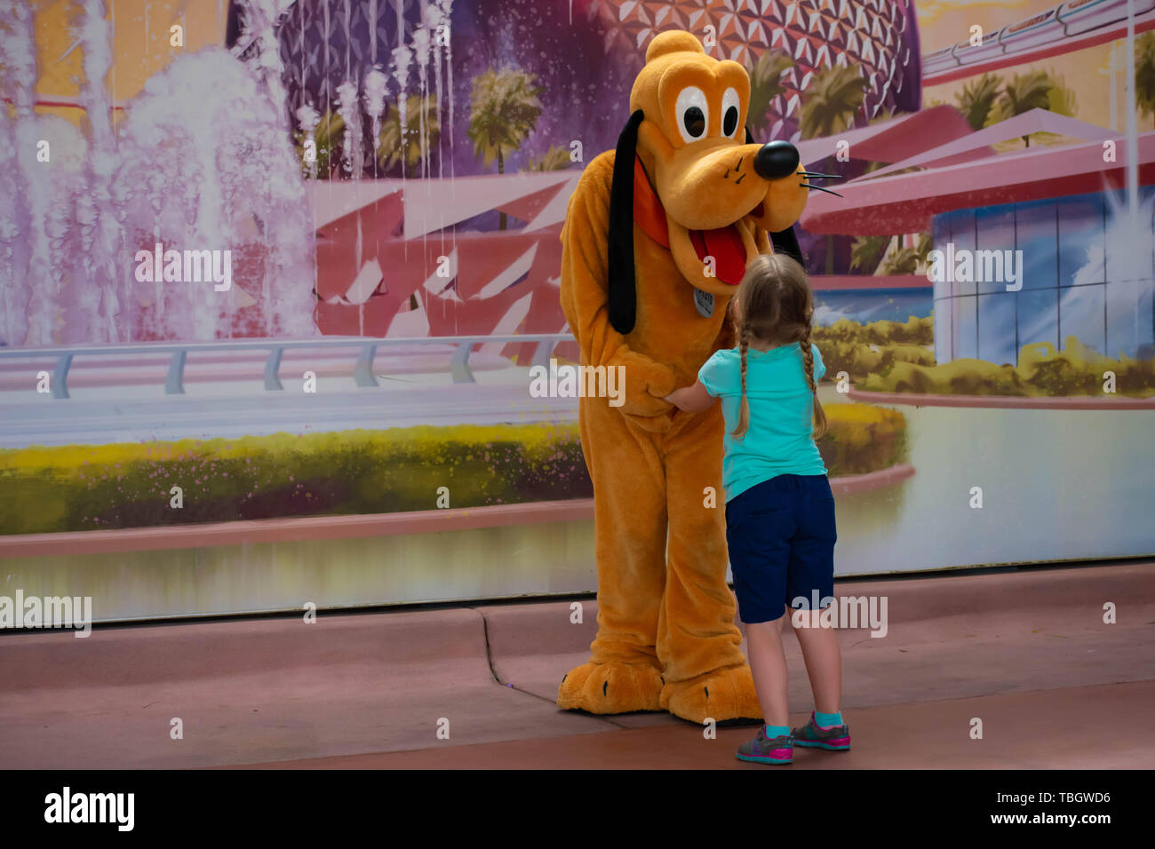 Orlando, Florida . March 27, 2019. Pluto playing with little girl at ...