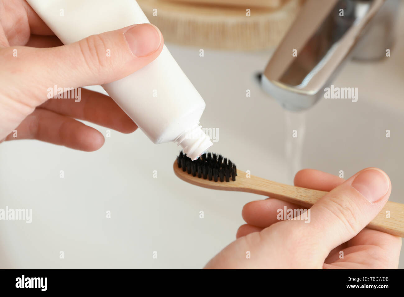 Woman squeezing toothpaste on brush in bathroom, closeup Stock Photo ...