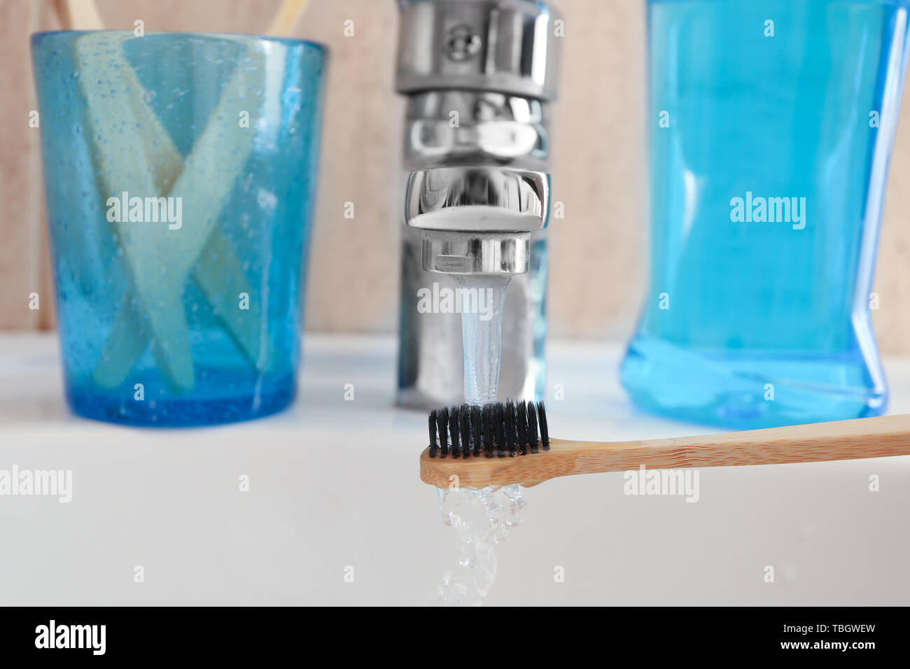 Toothbrush under jet of water in bathroom, closeup Stock Photo - Alamy