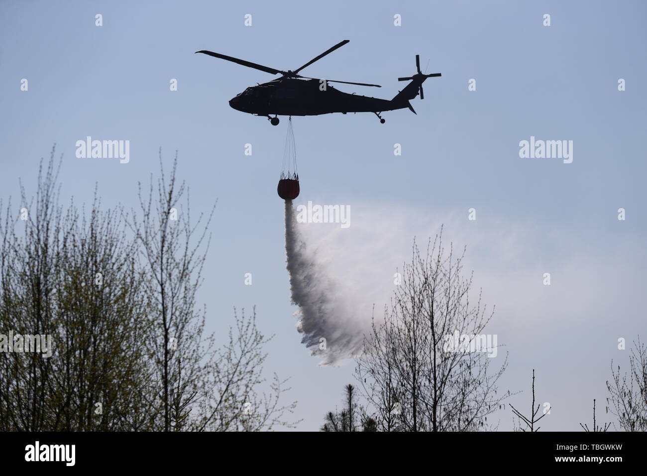 Helicopter water bombs over the forest fire just north of Tjällmo Stock ...