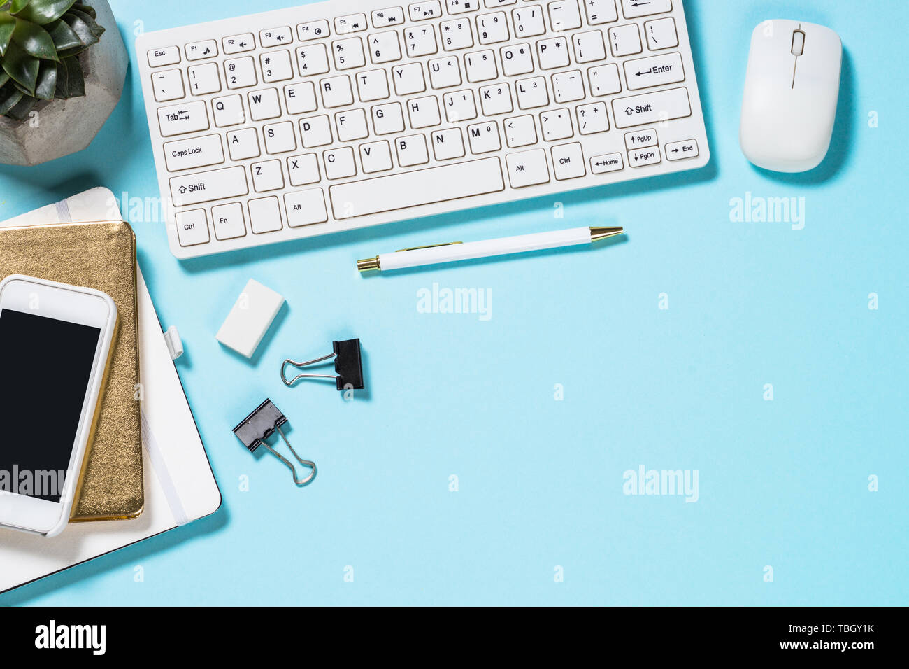 Office desk with keyboard and notebook on blue Stock Photo - Alamy