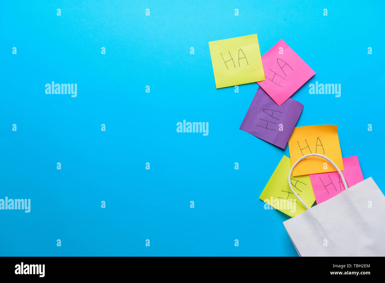 Paper bag with sticky notes on color background. April Fool's Day prank ...