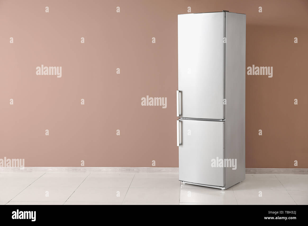 Modern fridge near color wall Stock Photo - Alamy