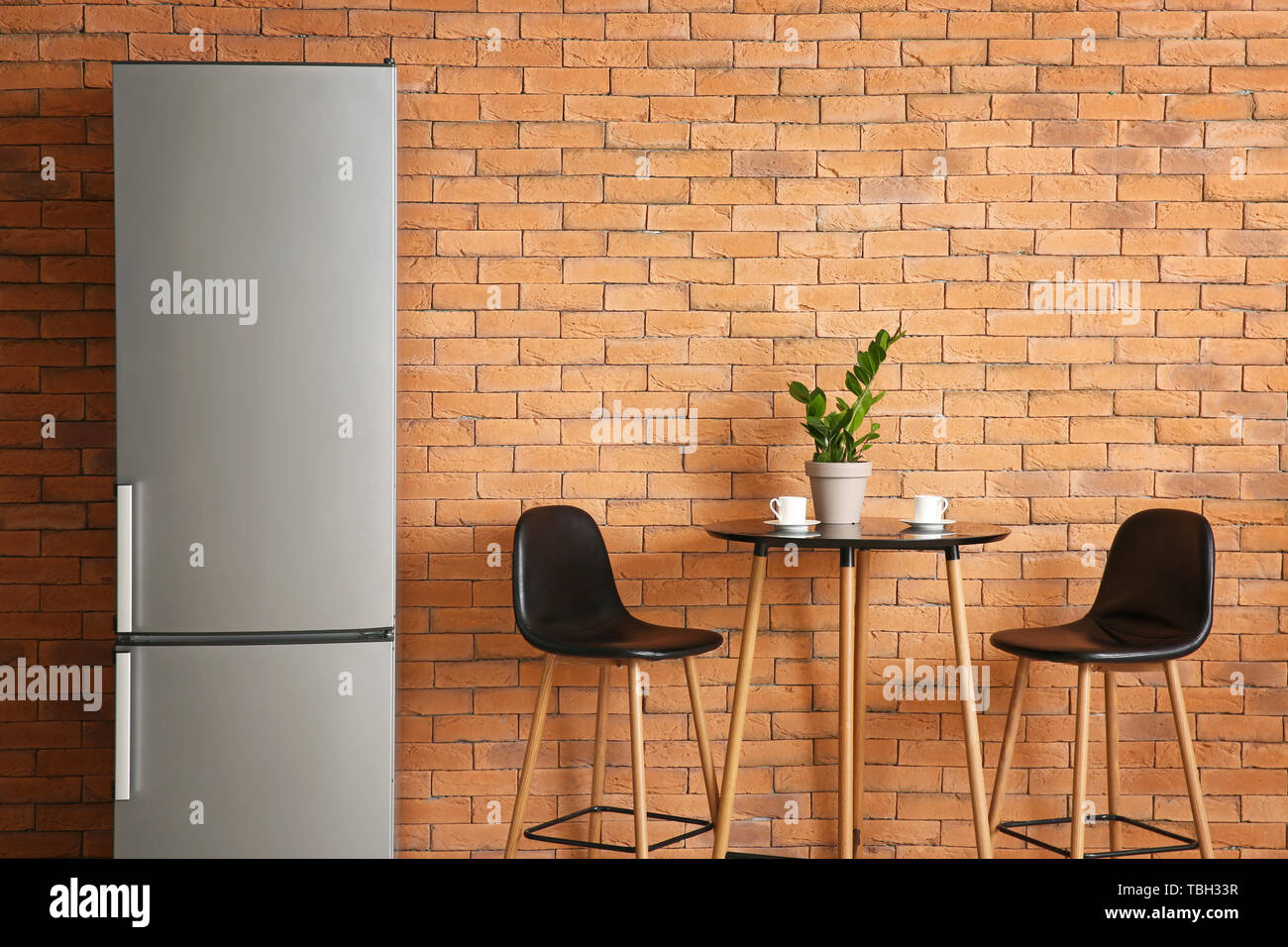Modern fridge, table and chairs in kitchen Stock Photo - Alamy