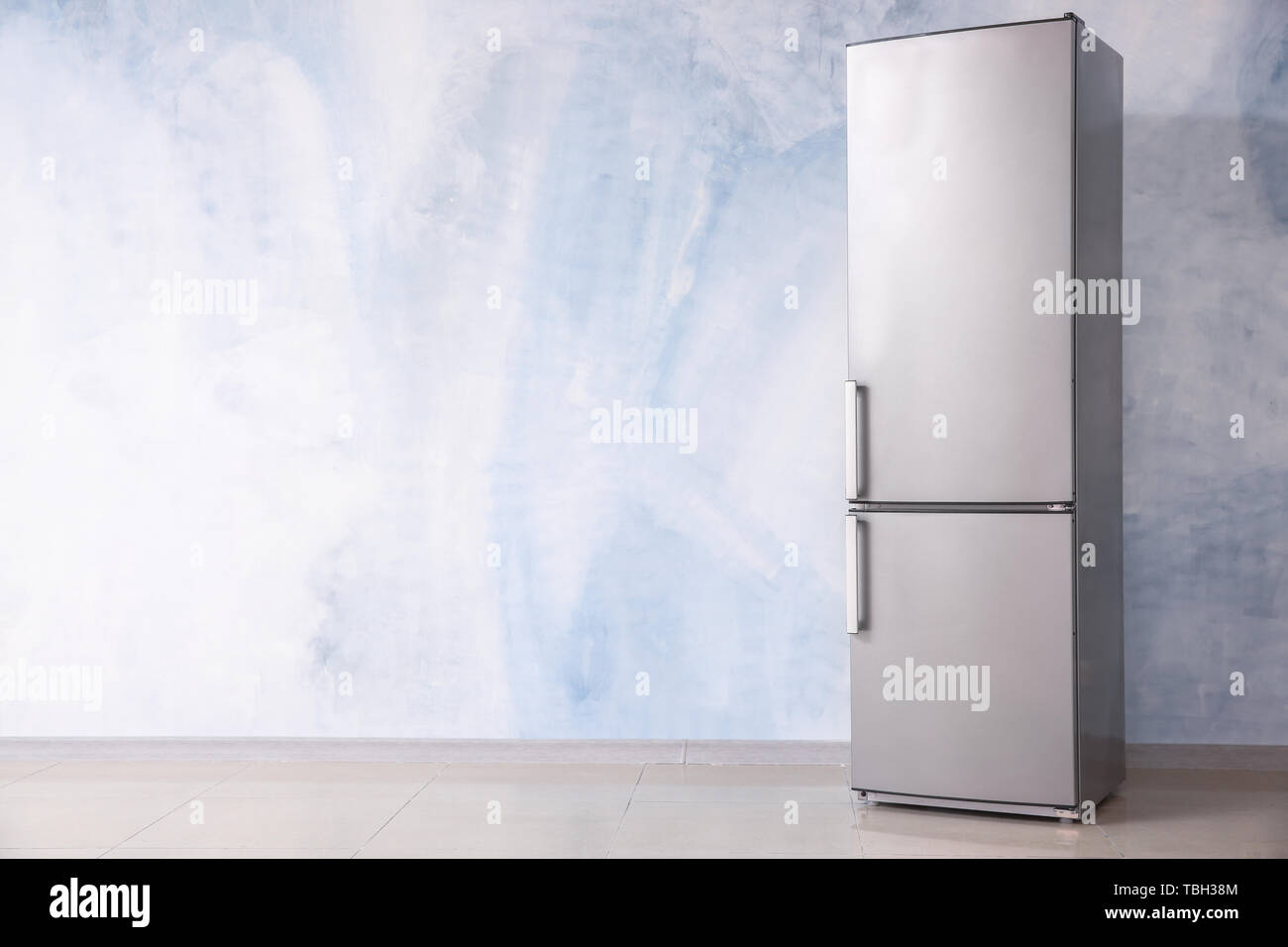 Modern fridge near color wall Stock Photo - Alamy