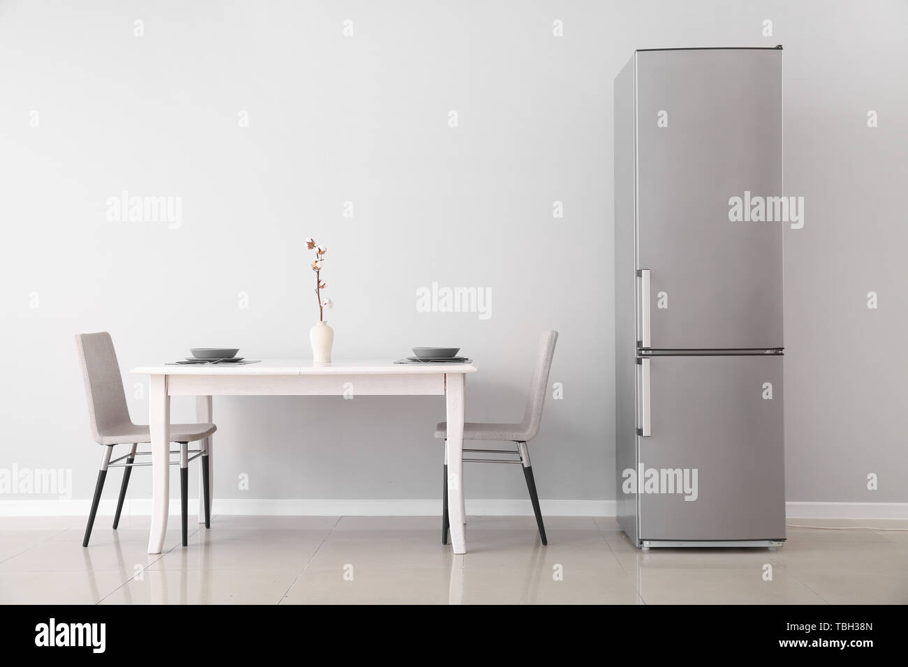 Modern fridge and served table in kitchen Stock Photo - Alamy