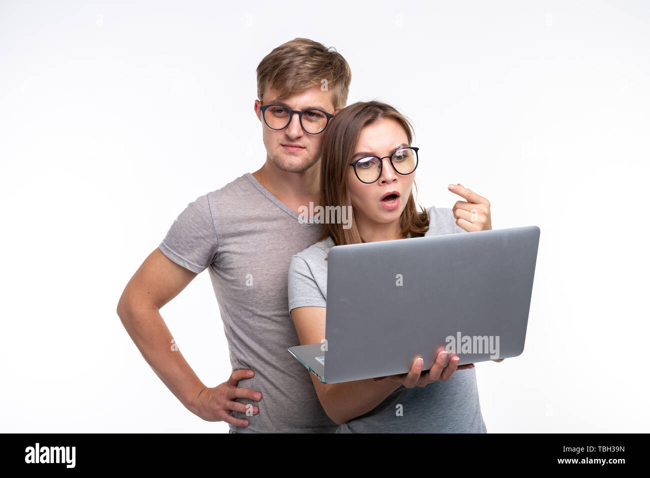 Nerds, study, people concept - a couple of students look at the netbook ...