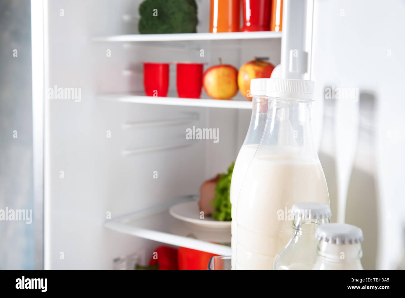 Bottles of milk in open fridge Stock Photo - Alamy