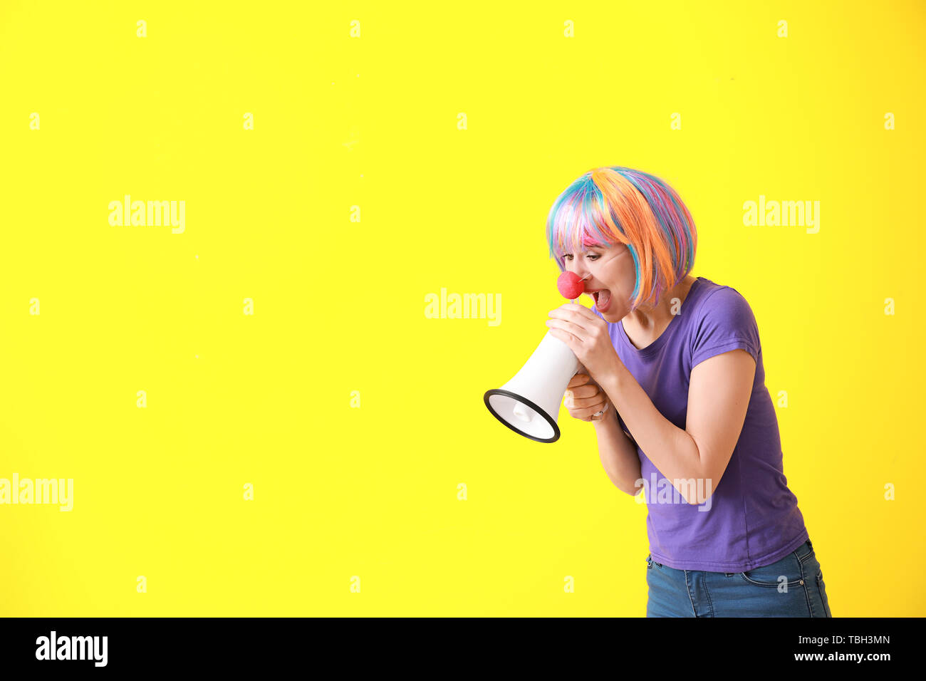 Funny woman with megaphone on color background. April Fools' Day prank ...