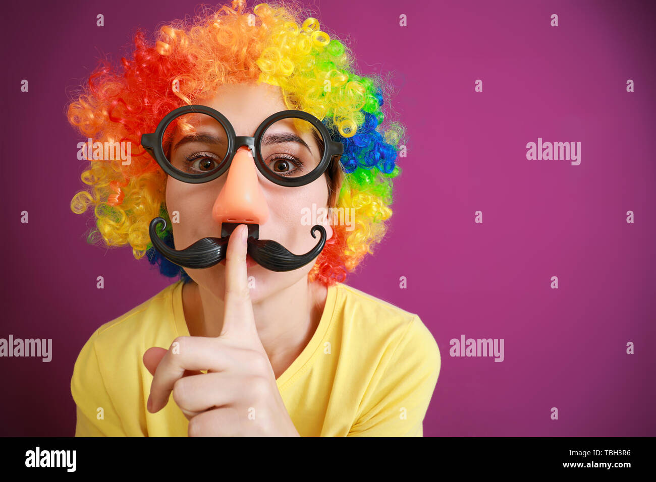 Funny woman with party decor for April Fools' Day on color background ...