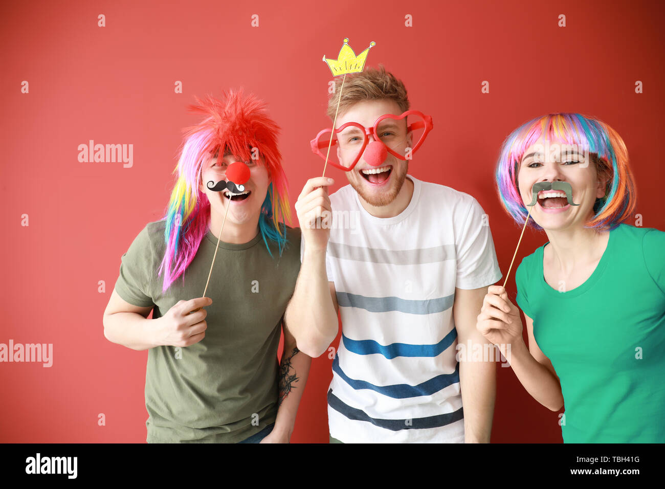 Funny friends with party decor for April Fools' Day on color background ...