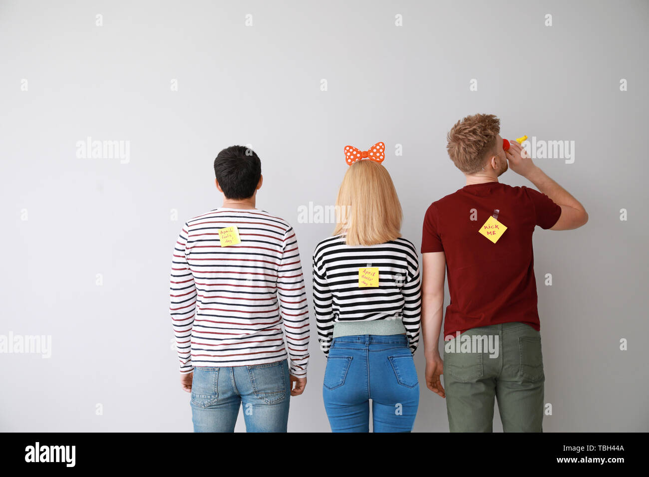 Sticky notes on back of friends against light background. April Fools ...