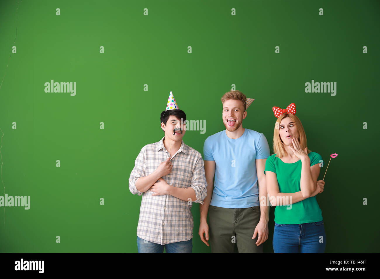 Funny friends with party decor for April Fools' Day on color background ...