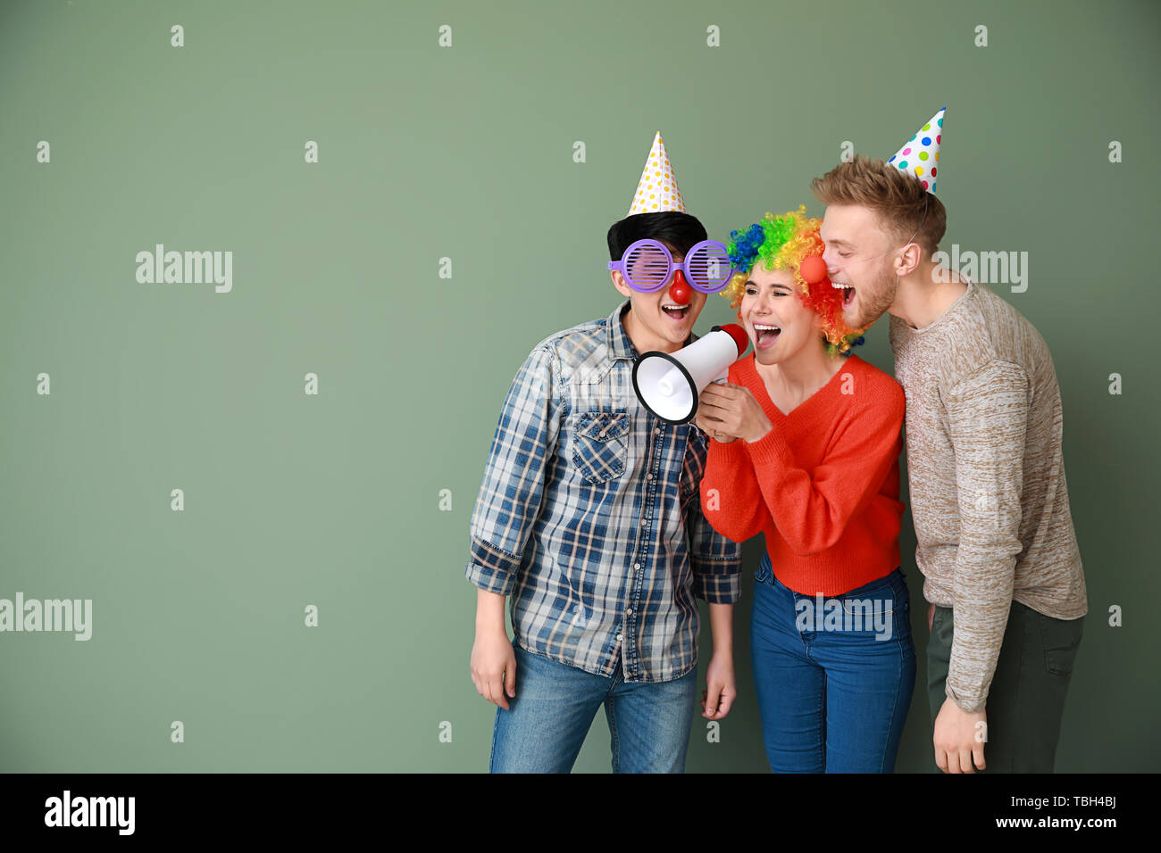 Funny friends with megaphone on color background. April Fools' Day ...