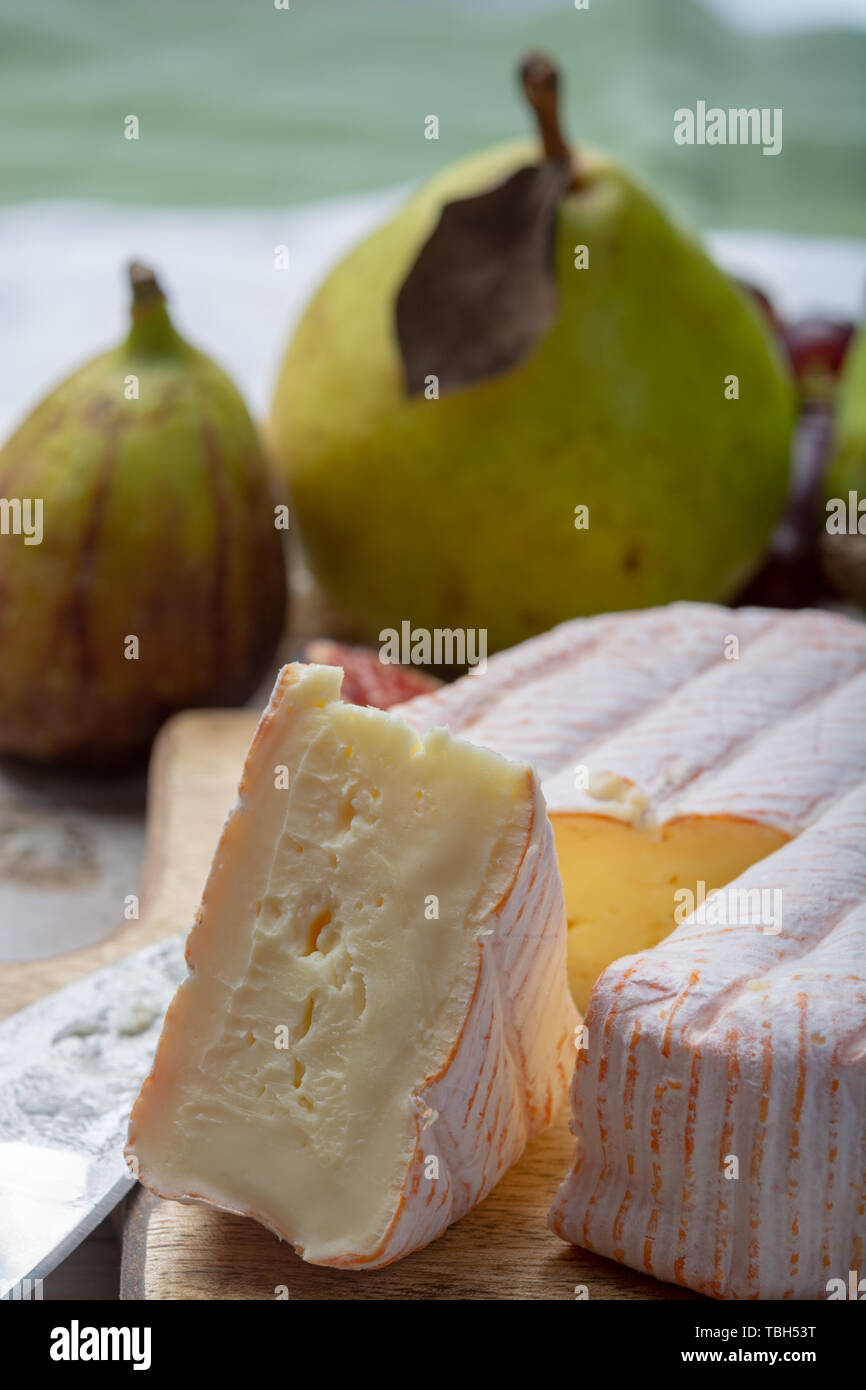 Round piece of French cheese Fleur Rouge made from cow milk served as ...