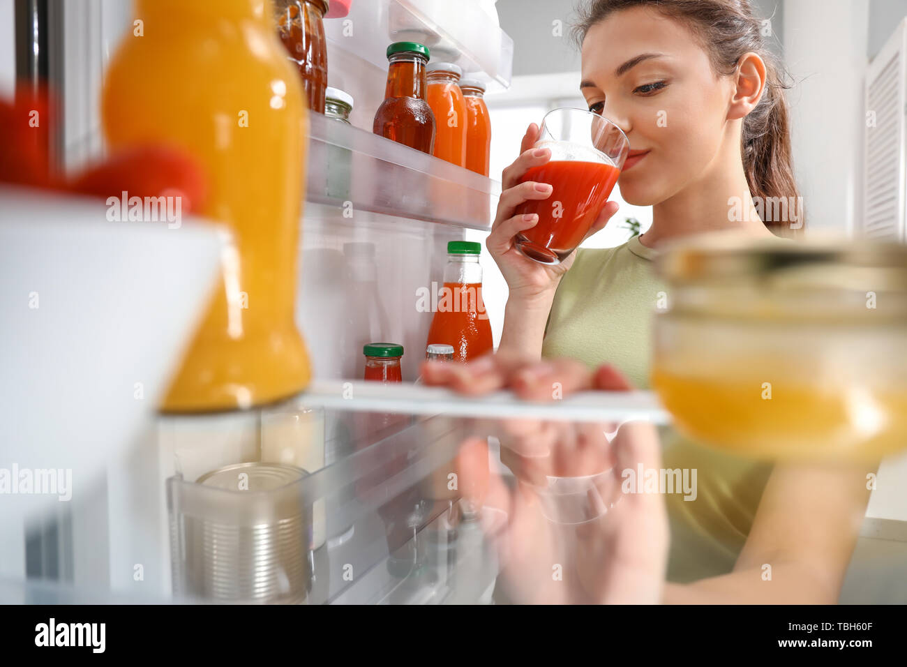 Woman taking food out of fridge at home, view from inside Stock Photo ...