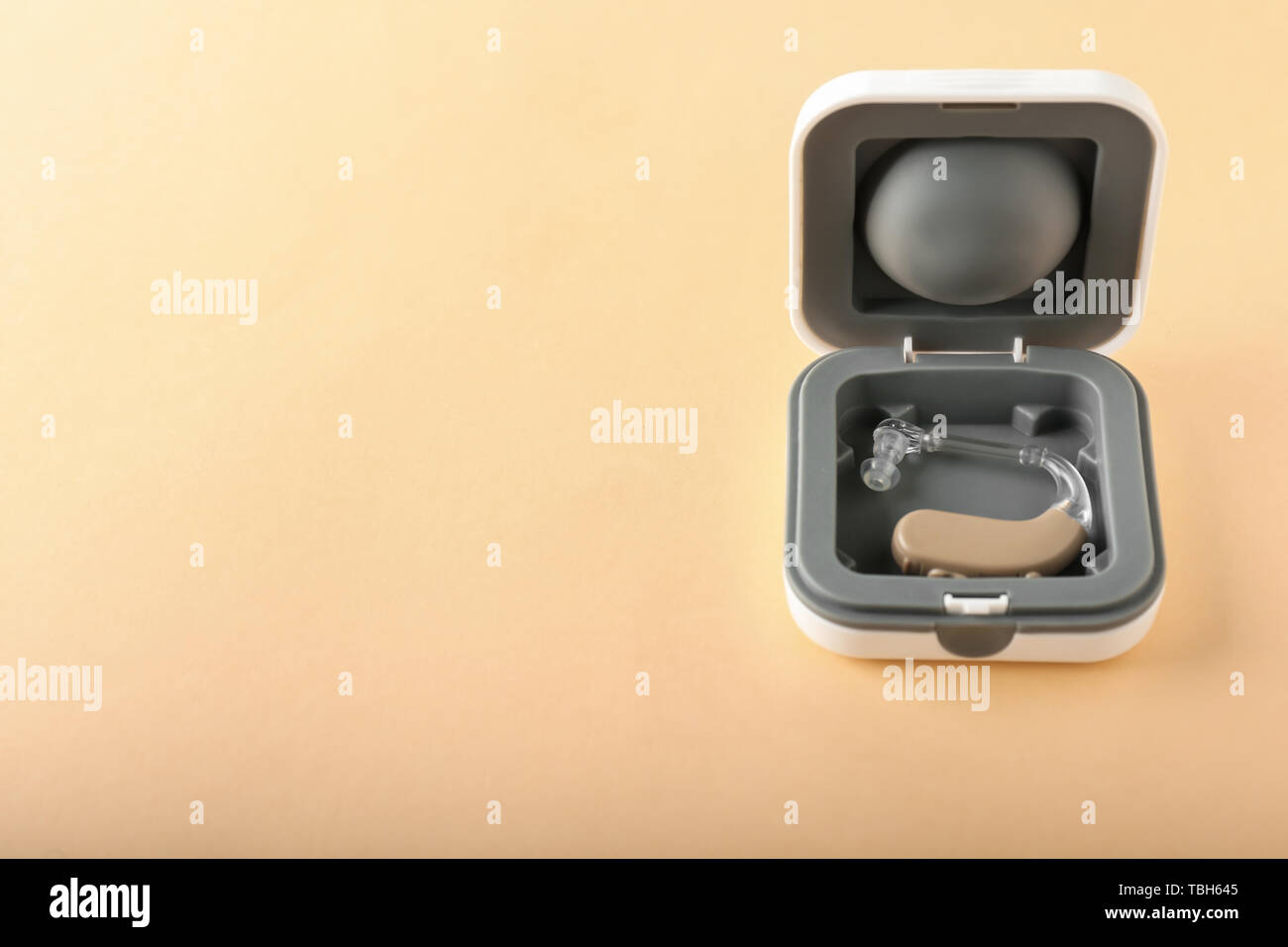 Box with hearing aid on color background Stock Photo - Alamy