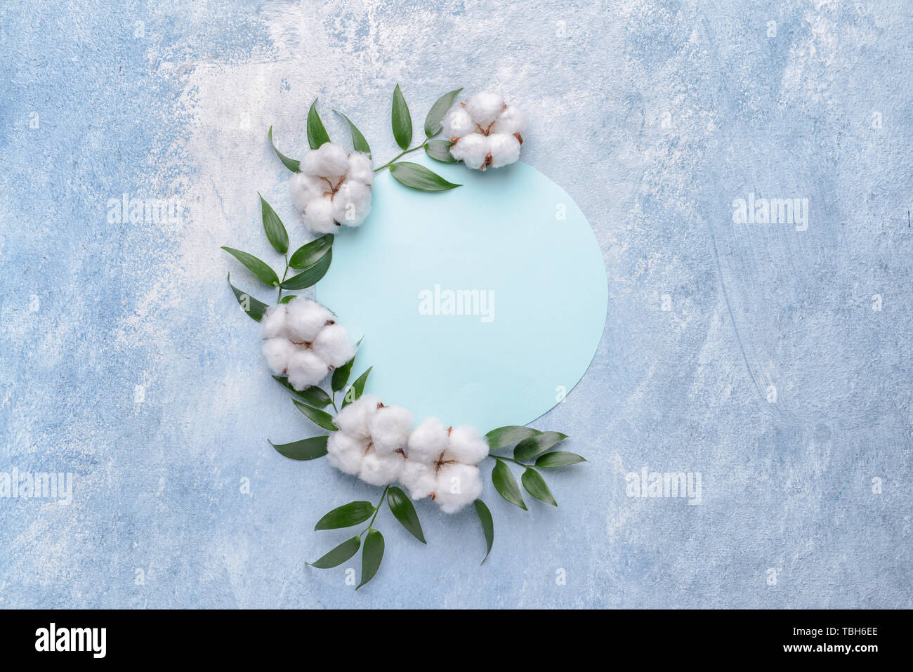Cotton flowers with sheet of paper on color background Stock Photo - Alamy