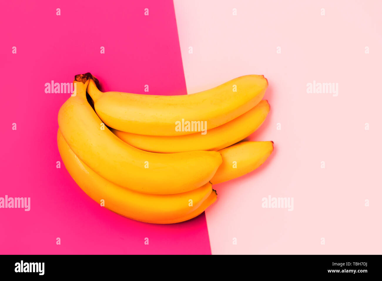 Bunch of bananas on colorful paper background Stock Photo - Alamy