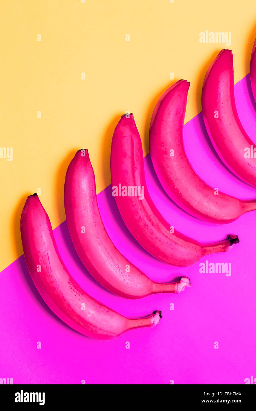 Closeup of pink bananas on purple and yellow background, top view ...