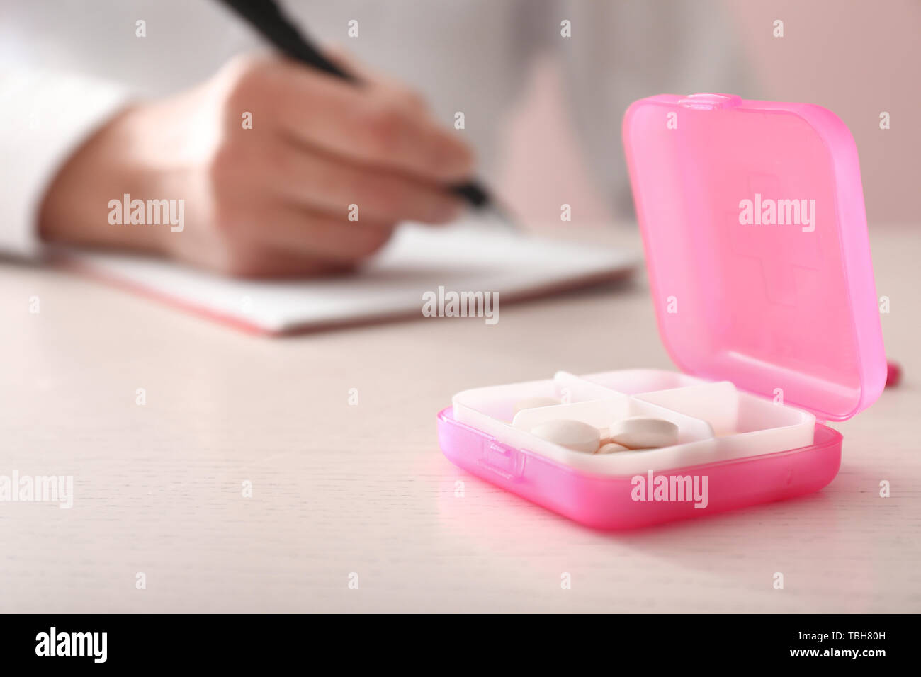 Container with pills on table Stock Photo - Alamy