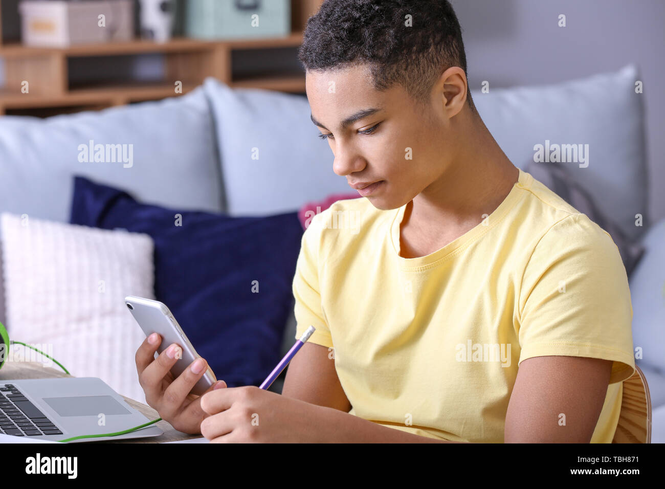 African-American teenage boy doing homework Stock Photo - Alamy
