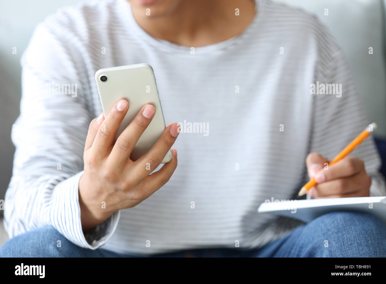 African-American teenage boy using mobile phone at home Stock Photo - Alamy