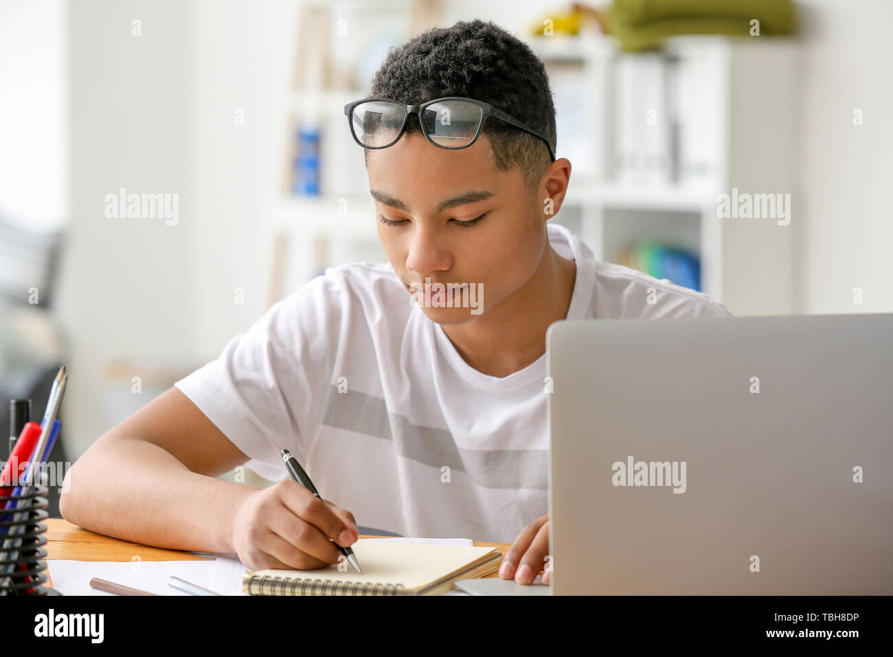 African-American teenage boy doing homework Stock Photo - Alamy