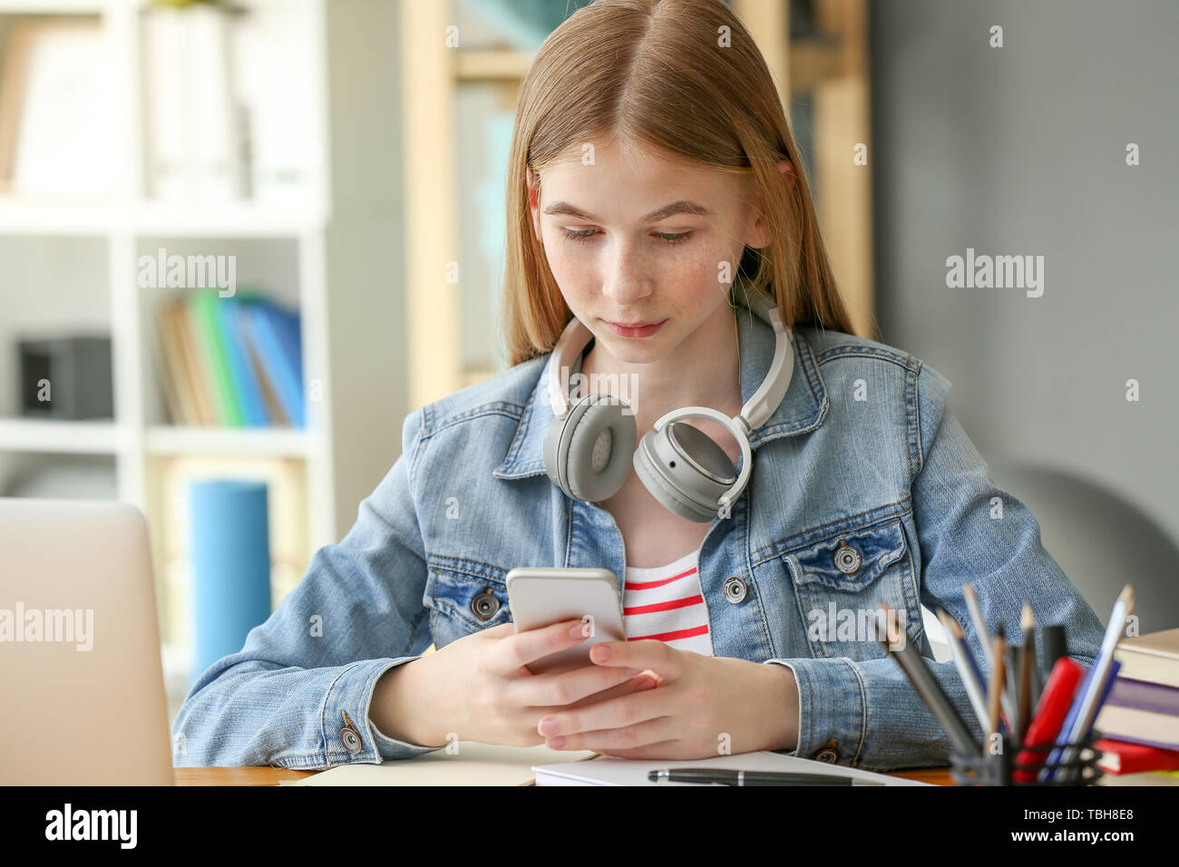 Cute teenage girl using mobile phone at home Stock Photo - Alamy