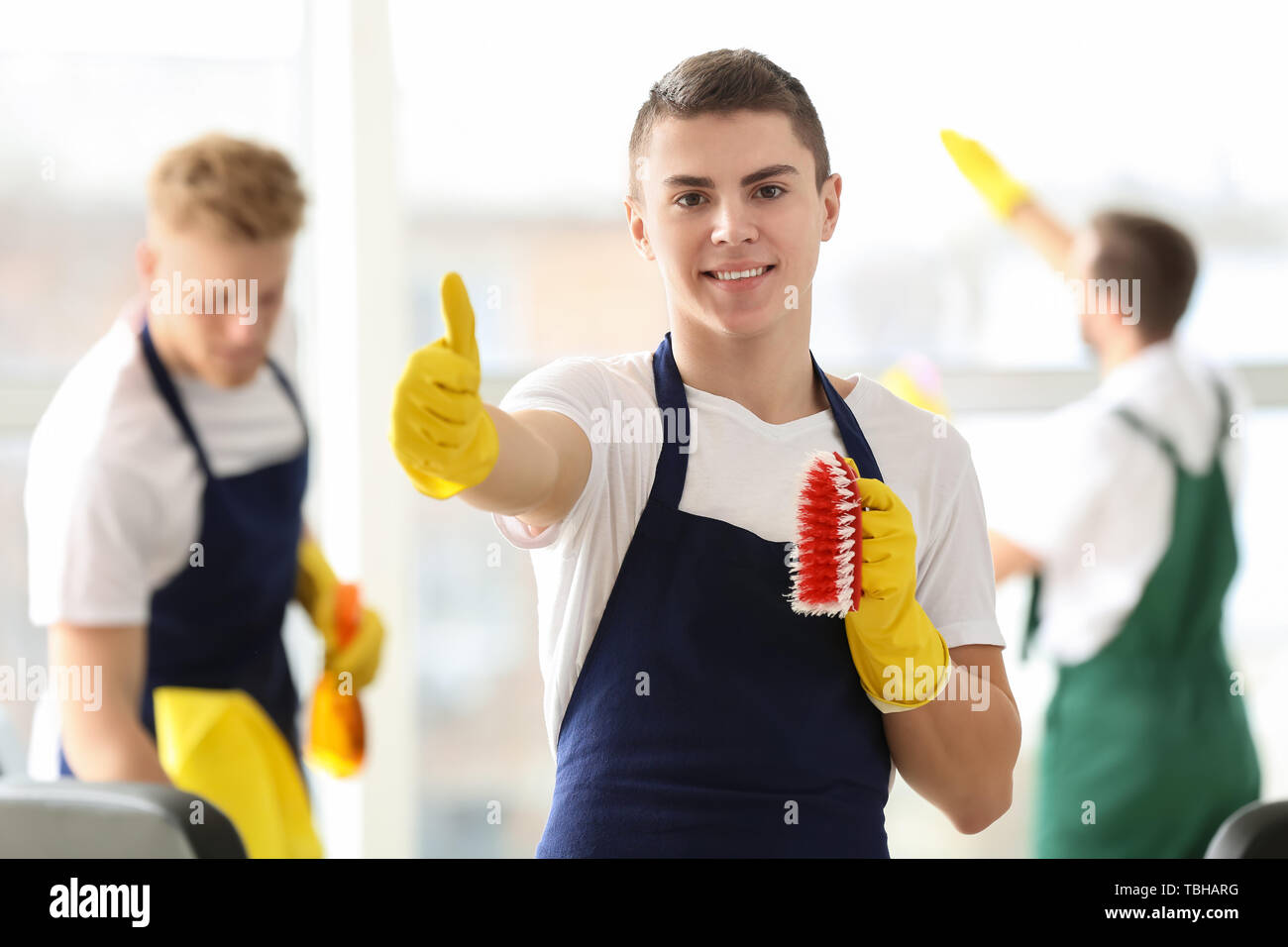 Male janitor showing thumb-up gesture in office Stock Photo - Alamy