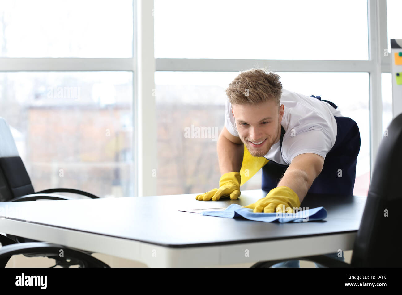 Man cleaning table in office hi-res stock photography and images - Alamy