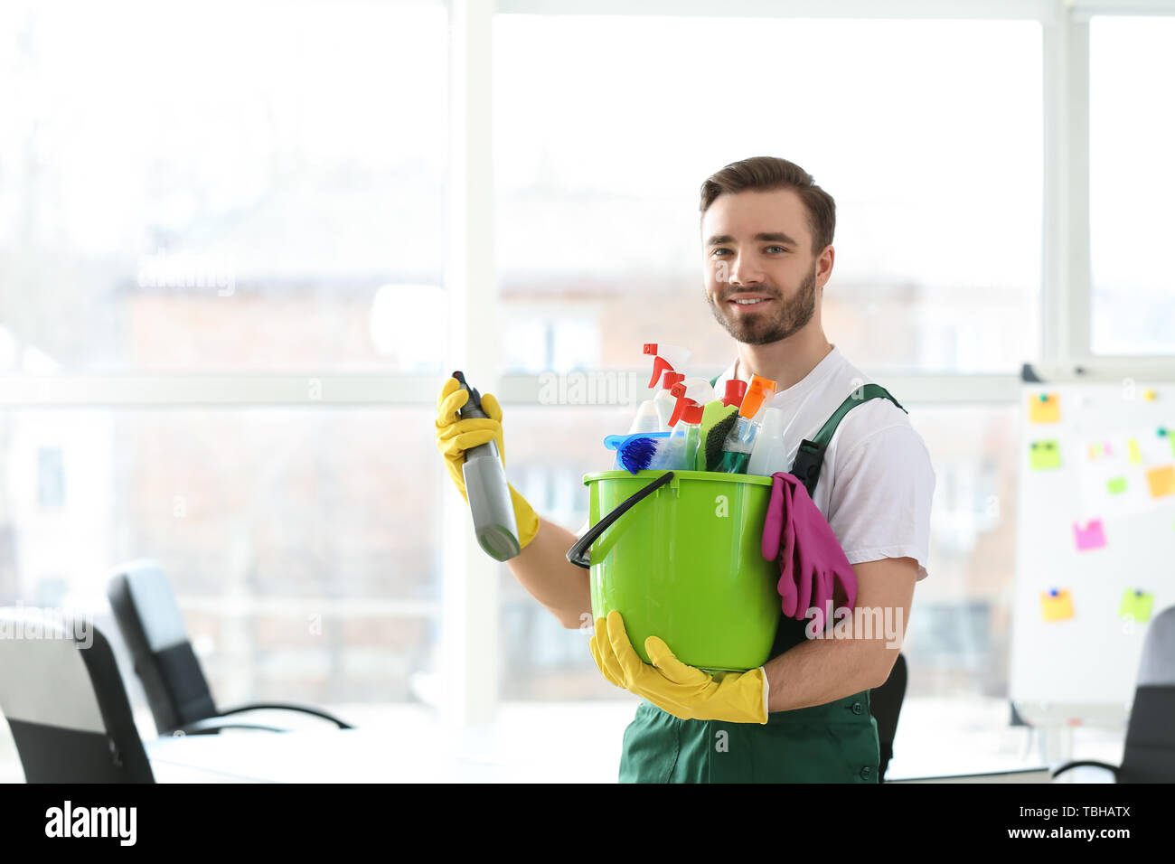 Male janitor with cleaning supplies in office Stock Photo - Alamy