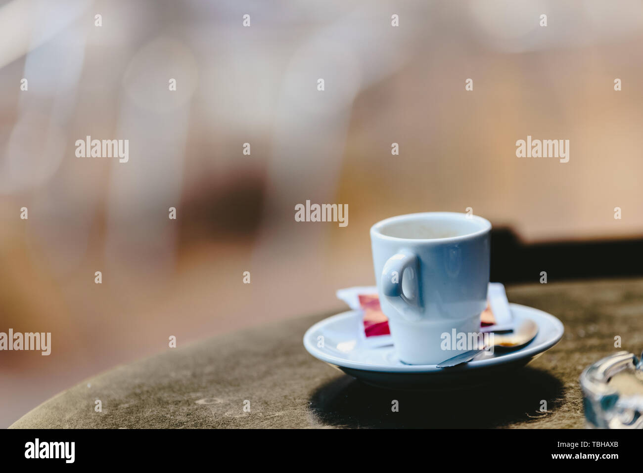 Empty white coffee cup on the wooden table of an outdoor bar, negative ...