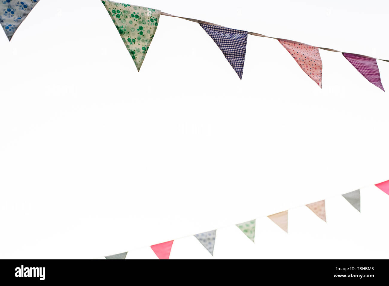 Pennants with blue sky background and pale colors hanging on a rope ...