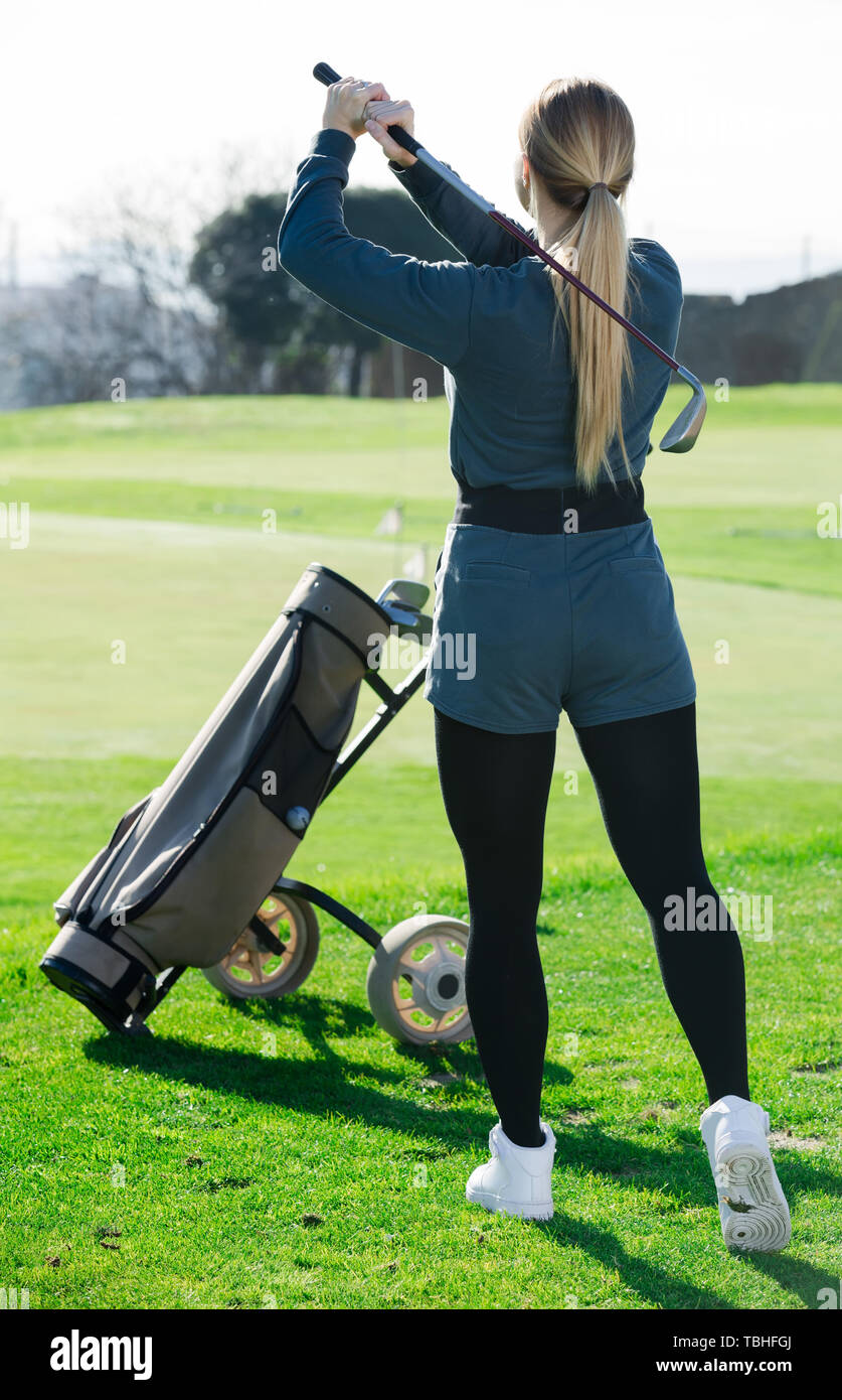 Young spanish woman golfer propelled ball successfully at golf course ...