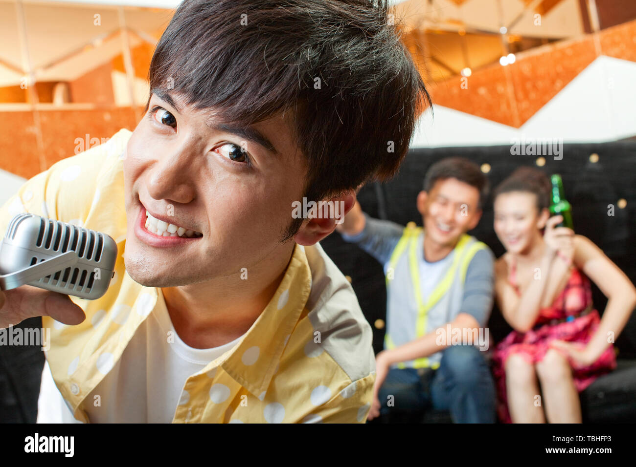 Three friends sing at KTV party Stock Photo - Alamy
