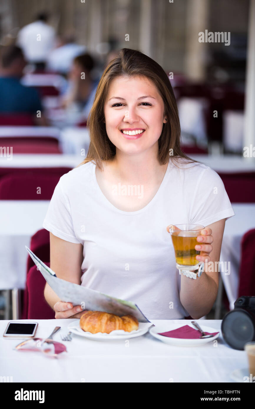 Tourist girl is drinking tea and plotting a route for walking on the ...