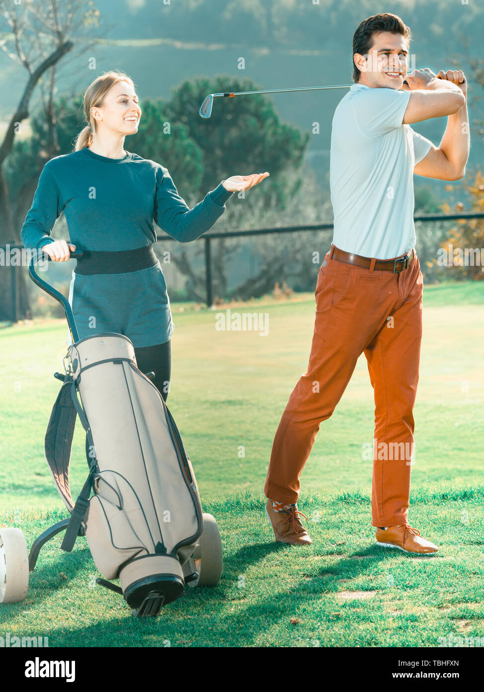 Young girl watching the game male golfer on a golf course Stock Photo ...